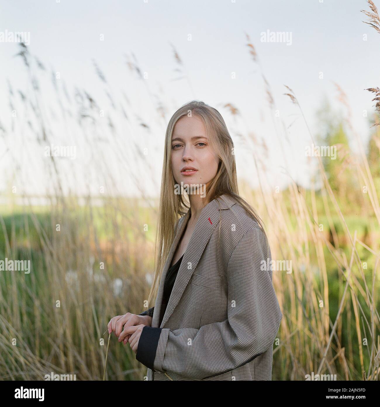 A beautiful woman stands among the reeds and smiles Stock Photo - Alamy