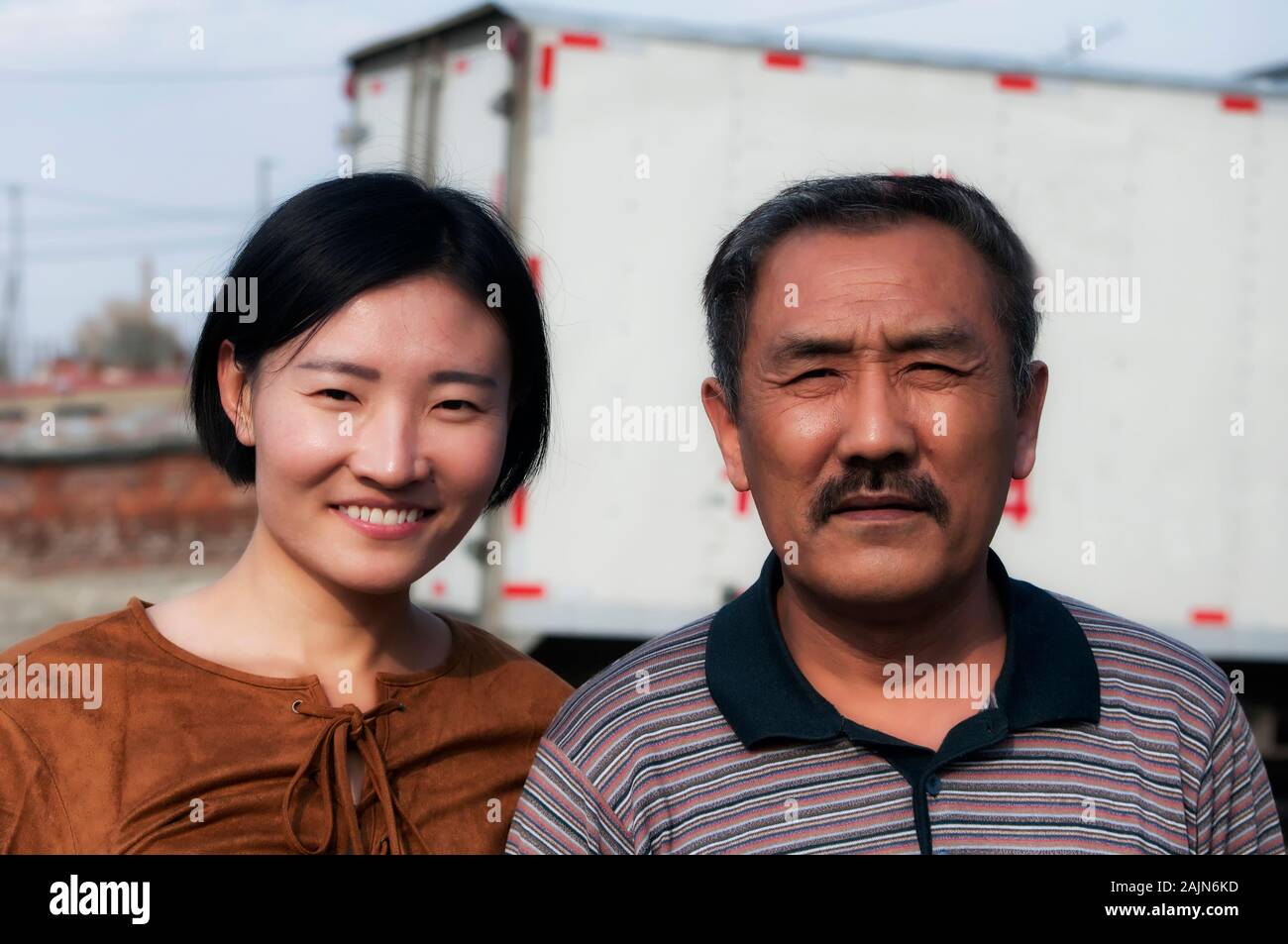 A chinese father and his daughter outside in a small city in ...