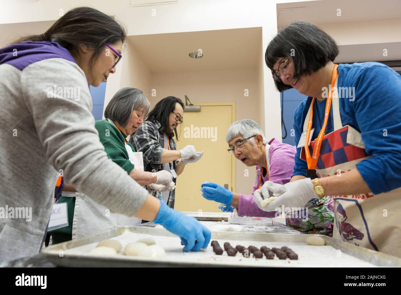 Volunteers form sweet rice and red bean paste into mochi at the Mochi ...