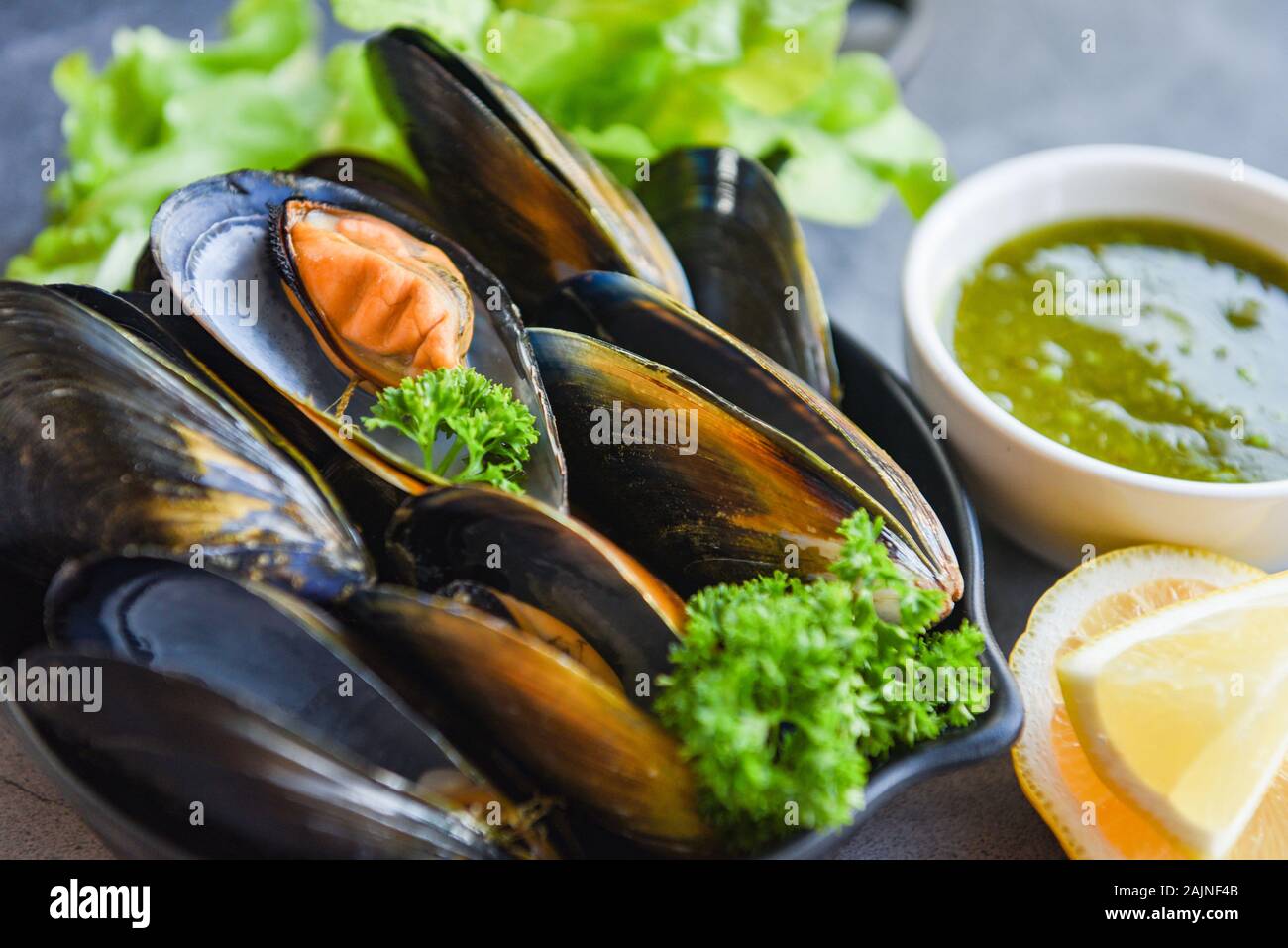 Cooked Mussels with herbs lemon and dark plate background / Fresh ...