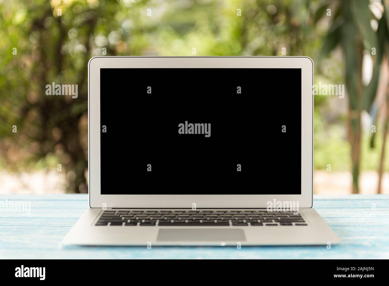 Laptop computer on table in nature background. mock up free space for ...