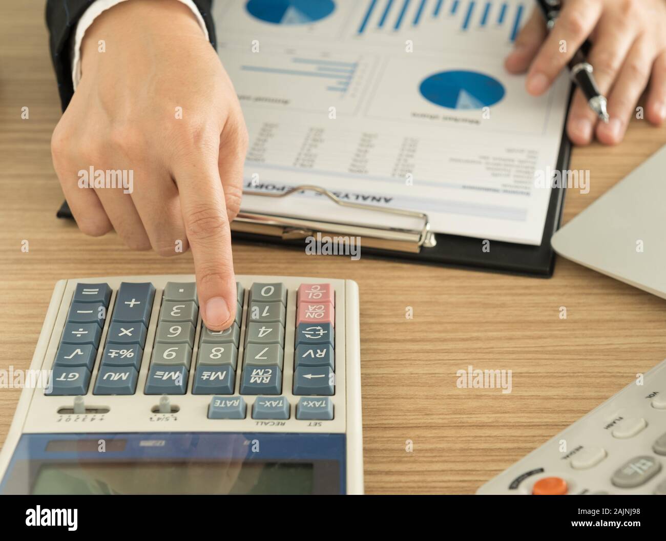 Businessman using a calculator to calculate the numbers Stock Photo - Alamy
