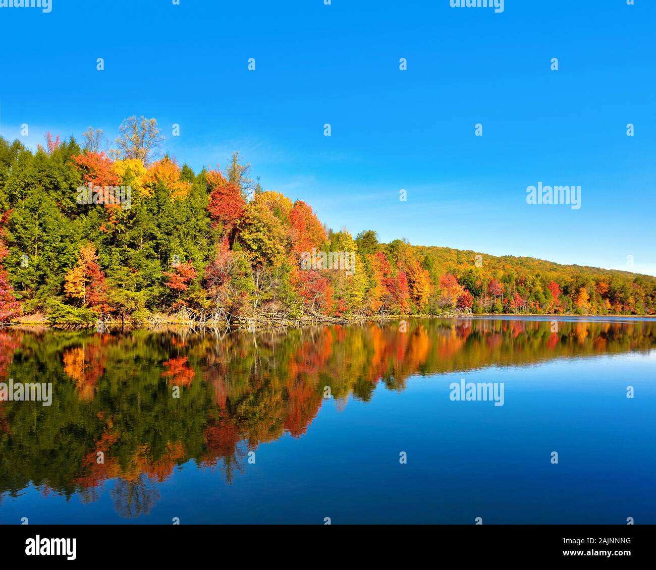 Beautiful autumn lake reflecting red fall colors in its clear water ...