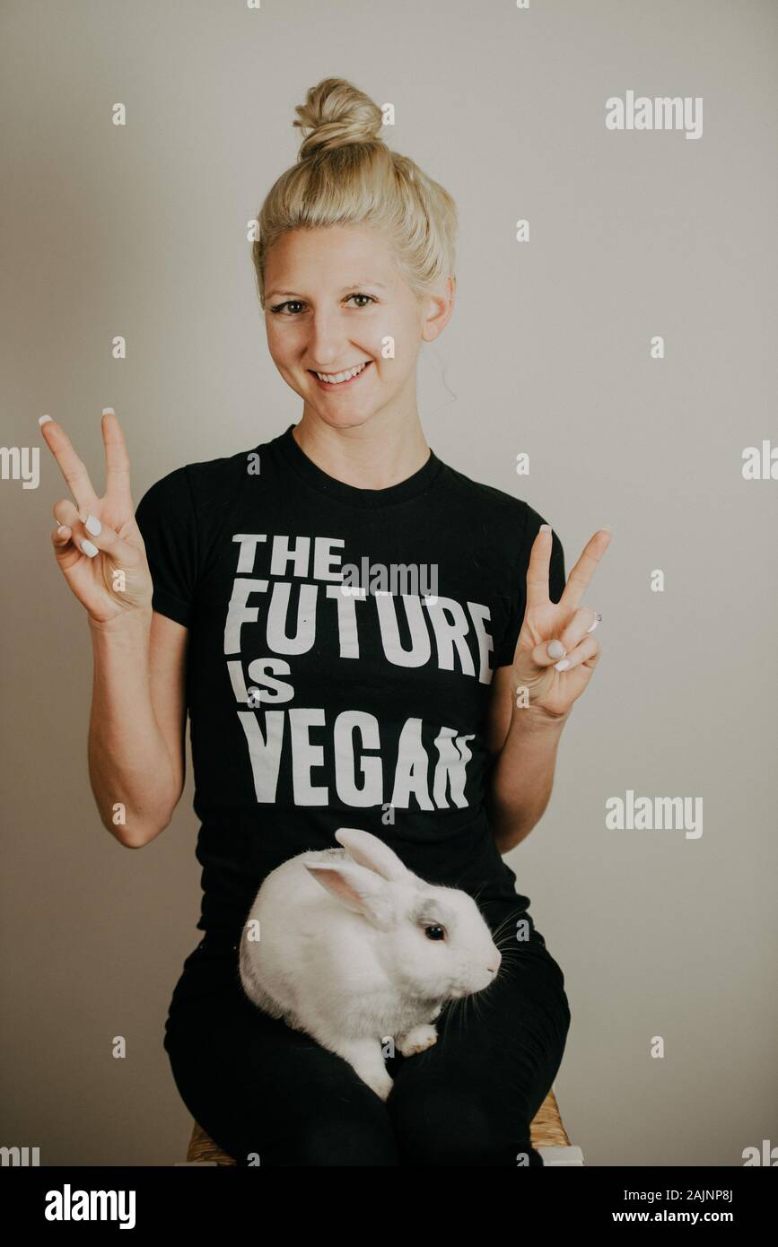 Blonde vegan girl with white rabbit wearing shirt that says the future ...