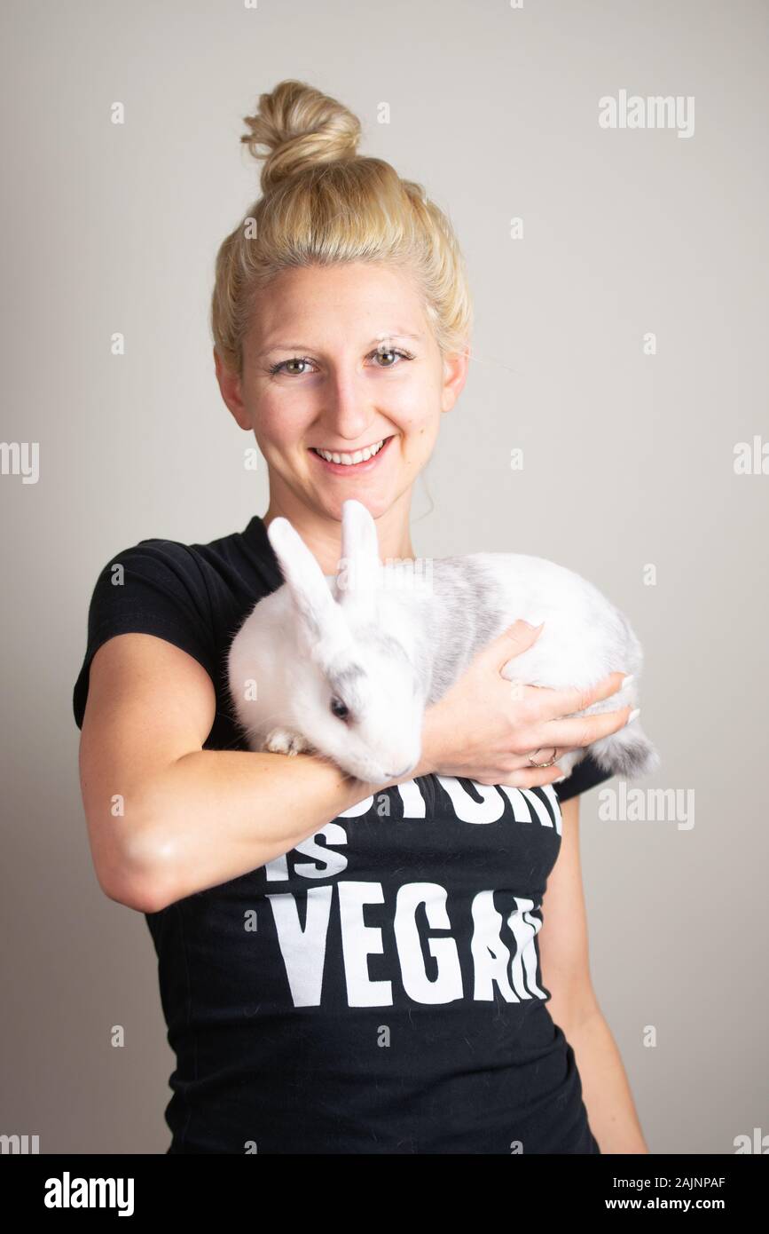 Blonde vegan girl with white rabbit wearing shirt that says the future ...