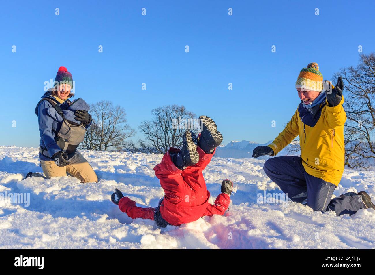 Family with little children having fun in fresh snow in afternoon Stock ...