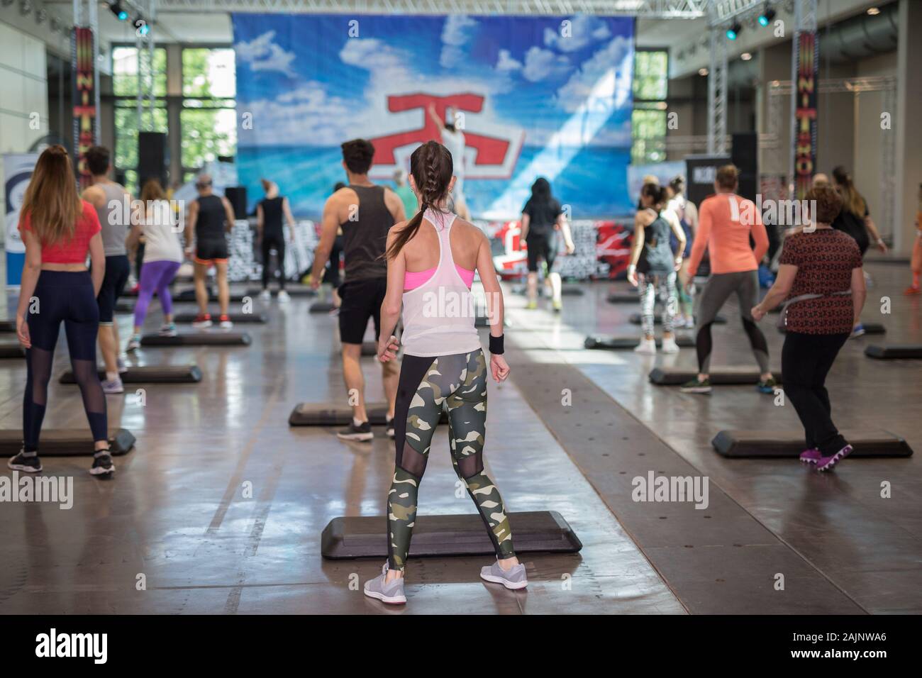 Fitness Workout in Gym: People doing Exercises in Class with Step ...