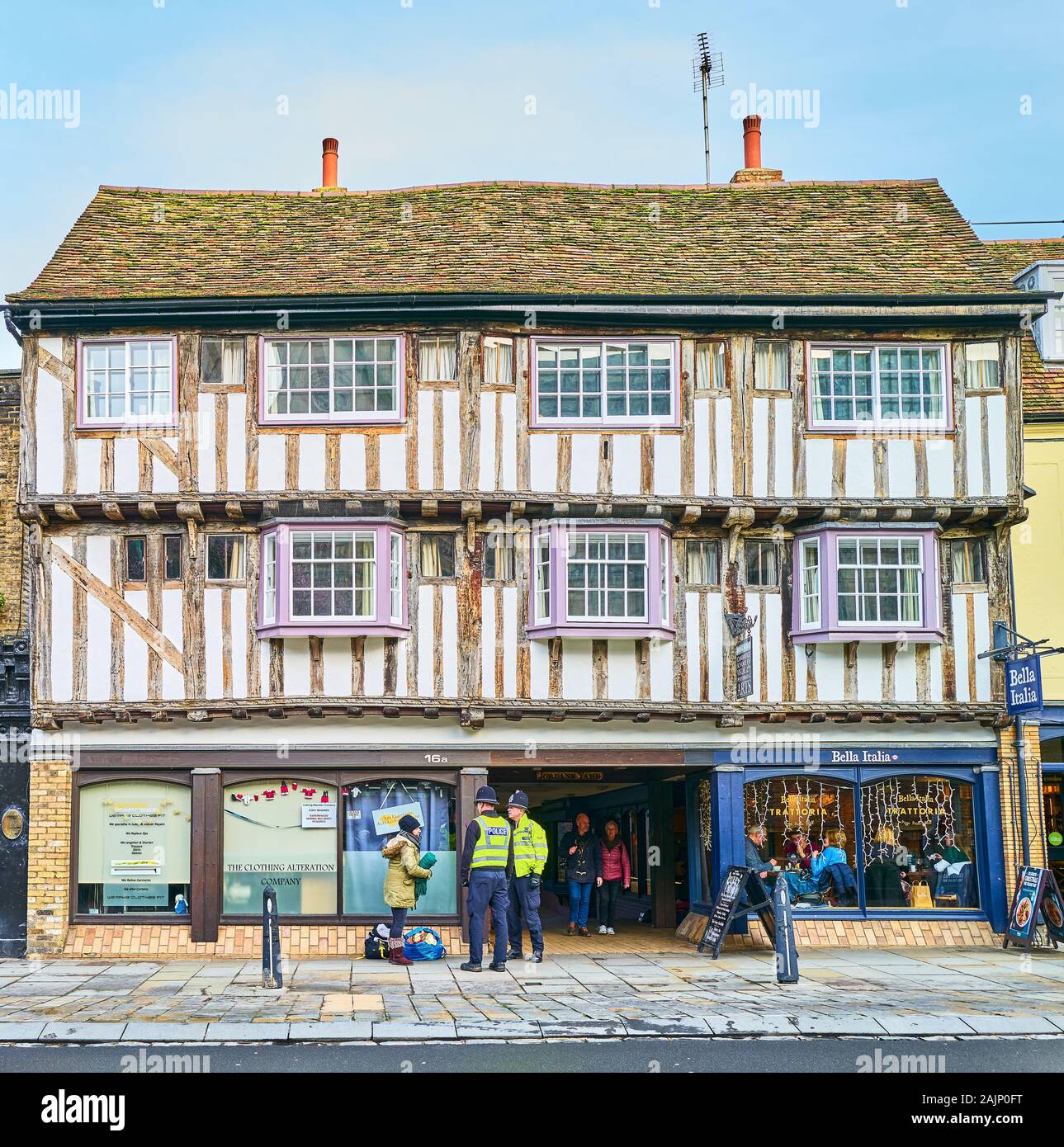 Two police officers talk with a homeless woman outside shops at a ...