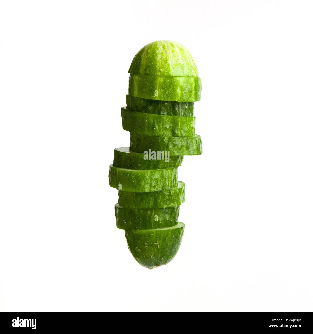 Flying vegetables. Fresh sliced cucumber isolated on white background ...