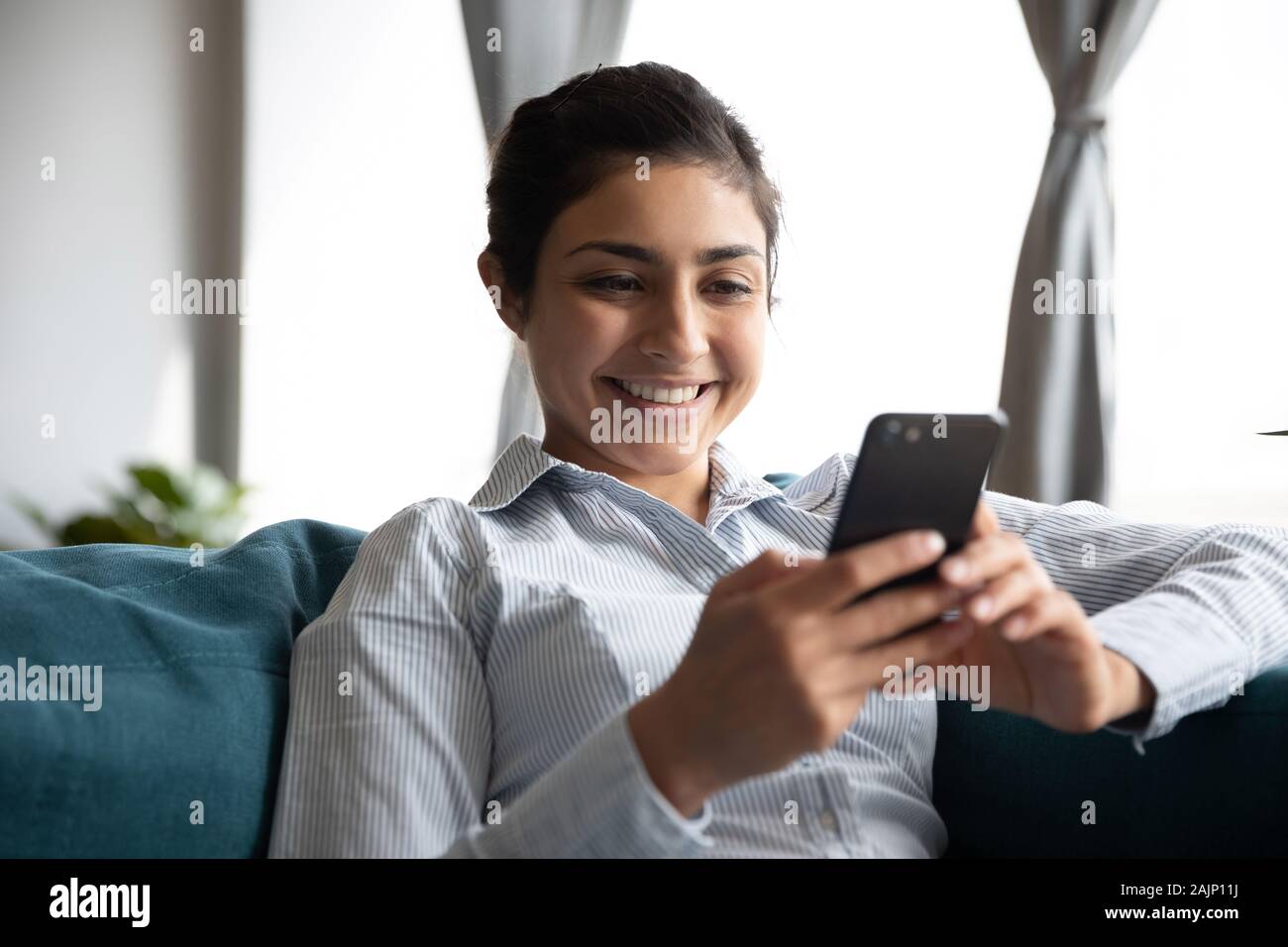 Indian girl using phone sofa hi-res stock photography and images - Alamy