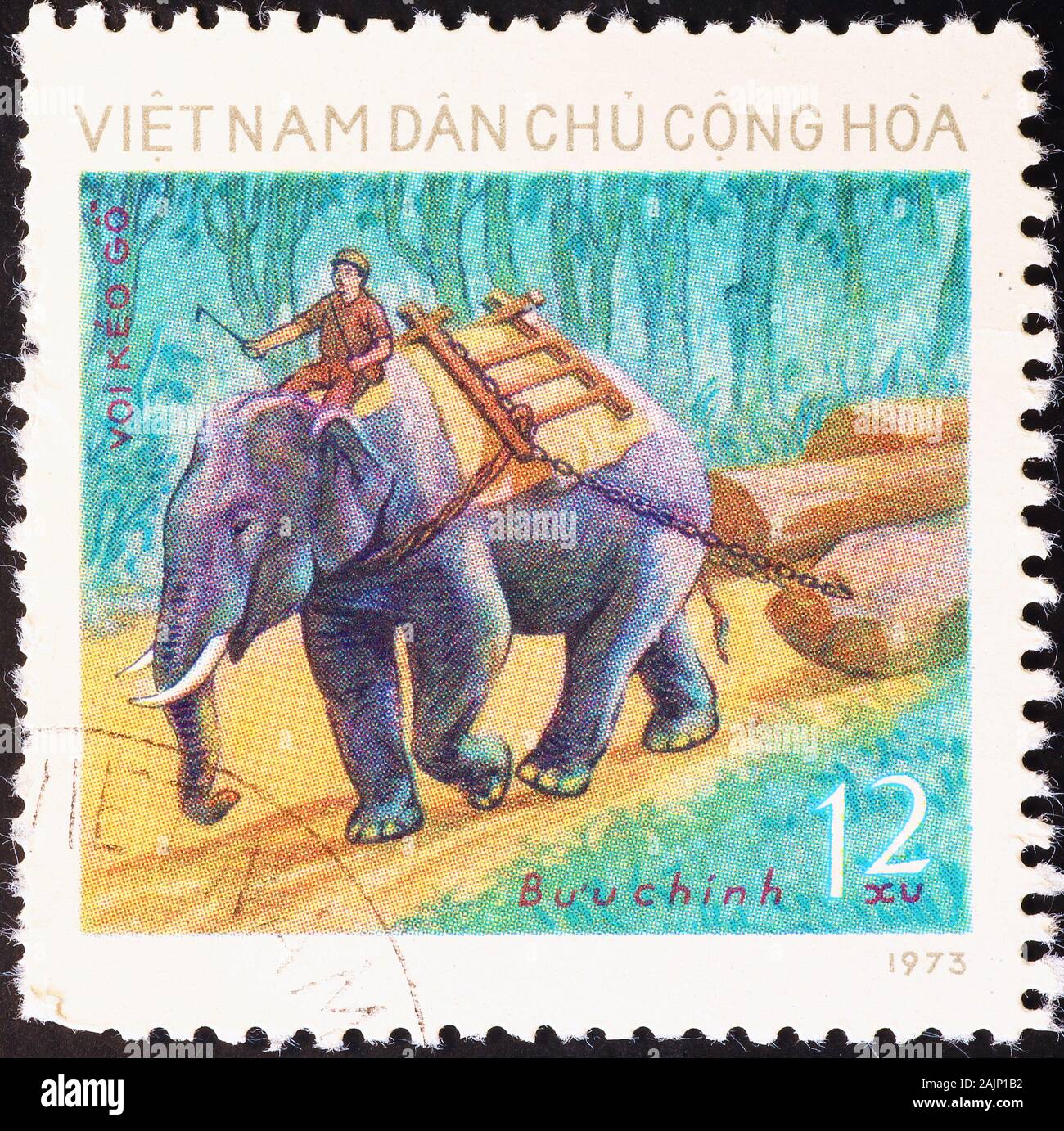 Elephant pulling log on vietnamese postage stamp Stock Photo - Alamy