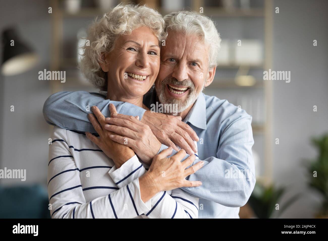 Elderly 65s couple in love embracing smile look at camera Stock Photo ...
