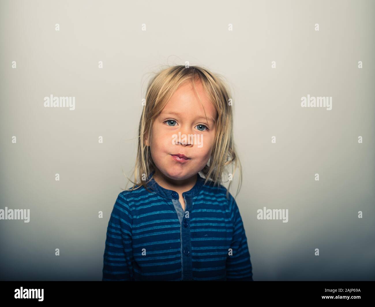 Studio portrait of toddler pulling faces Stock Photo - Alamy