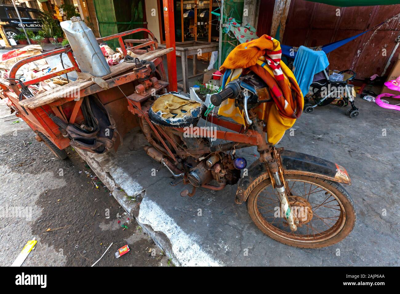 An old dilapidated motorcycle with an attached trailer serves as a ...