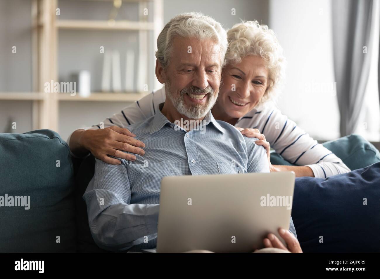 Elderly couple using laptop enjoy virtual entertainment Stock Photo - Alamy