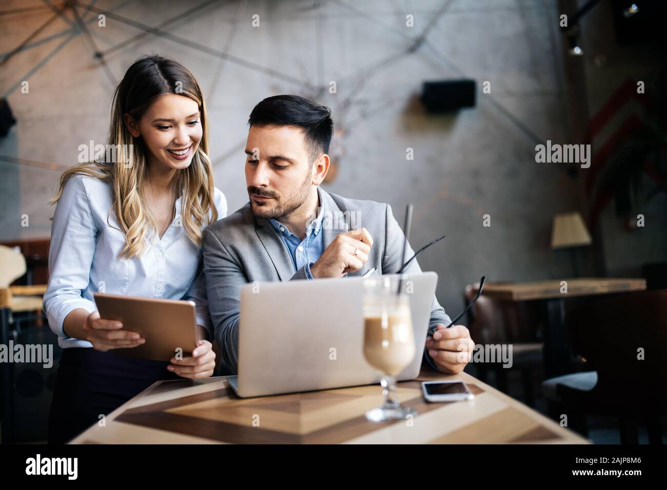 Cheerful coworkers in office working and brainstorming together Stock ...