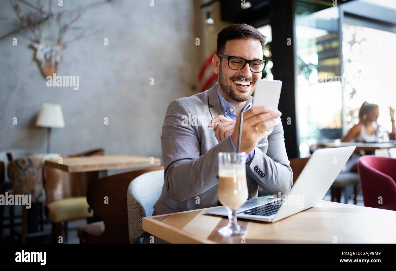 Handsome business man receiving a happy message on his cell phone Stock ...