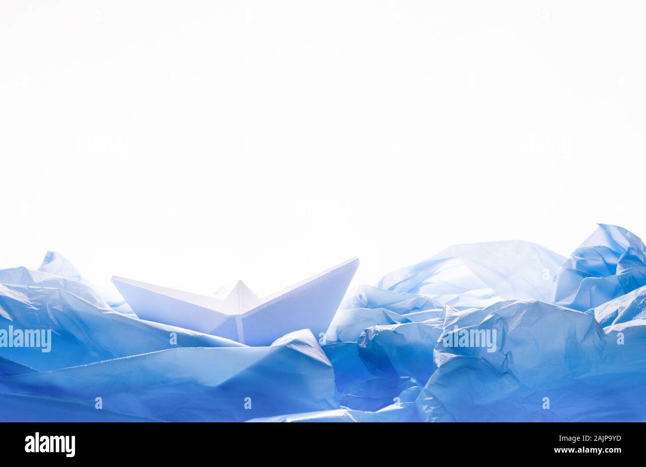 Global problem of plastic waste in the ocean. Paper boat in water of ...