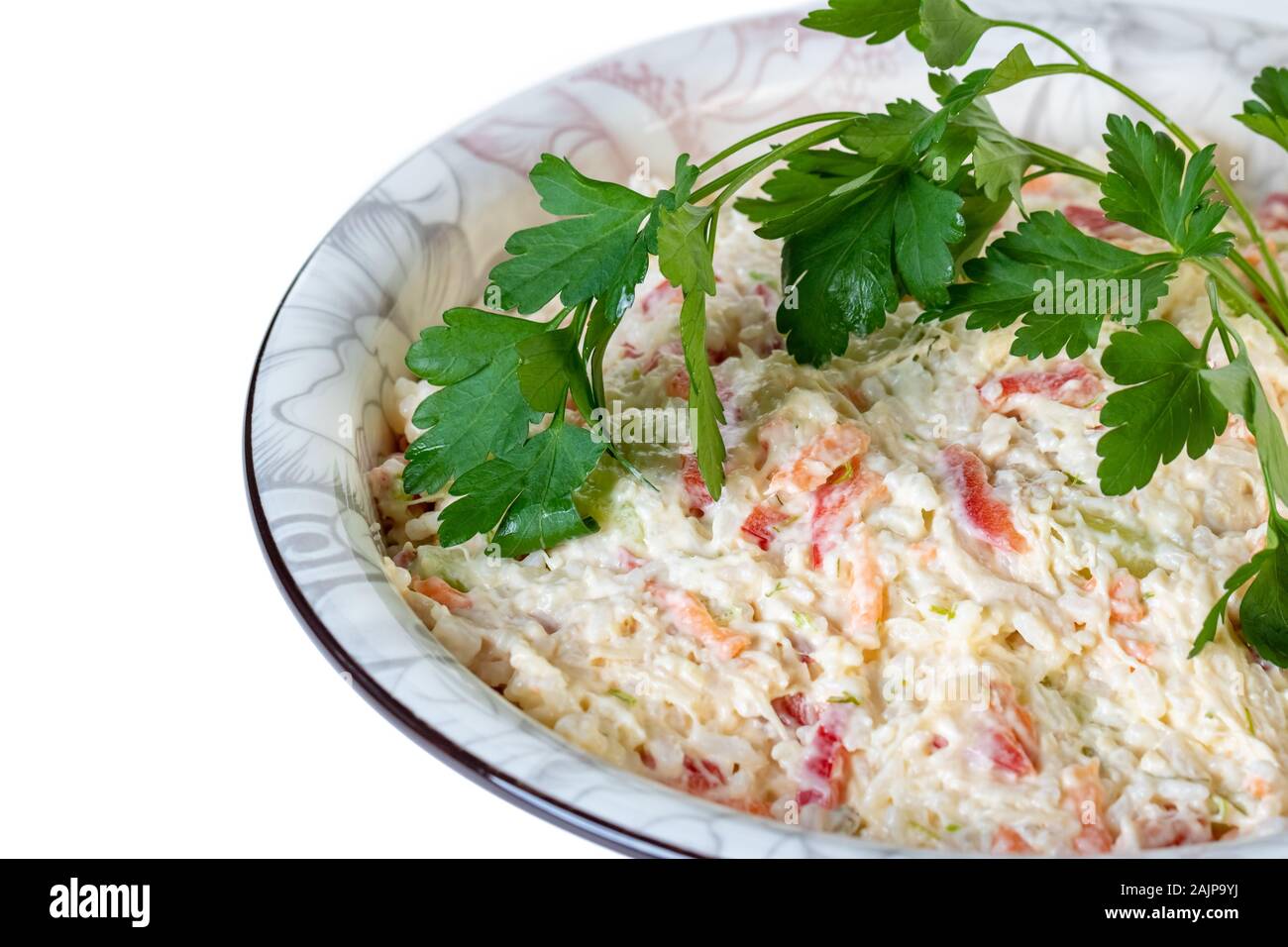salad of rice, vegetables with mayonnaise in a bowl on a white ...