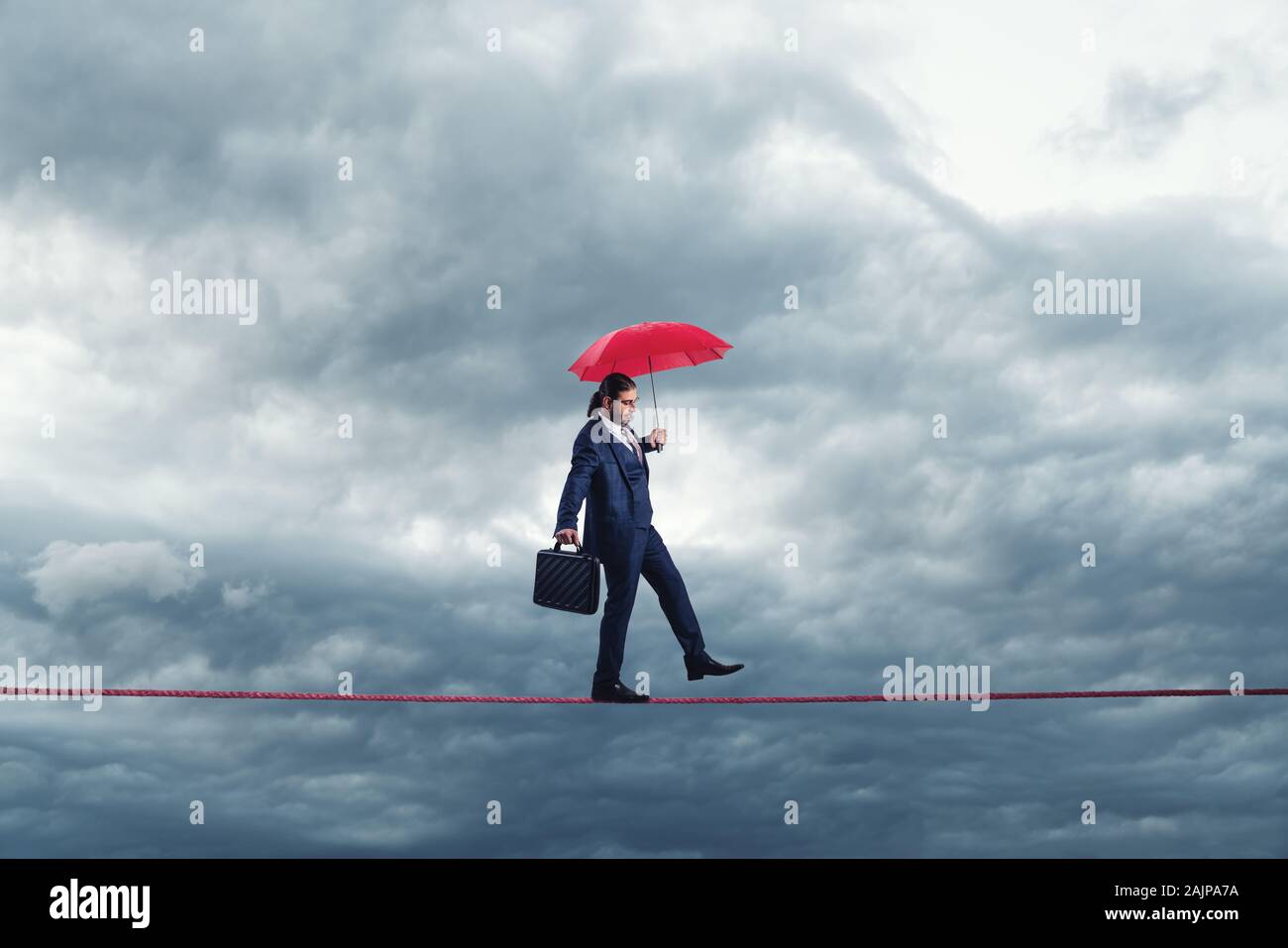 Businessman is walking on a thiny rope, metaphoring risky business life ...