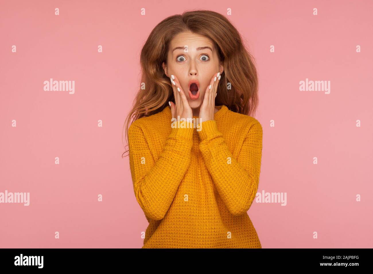 Portrait of extremely excited shocked ginger girl in sweater jumping ...