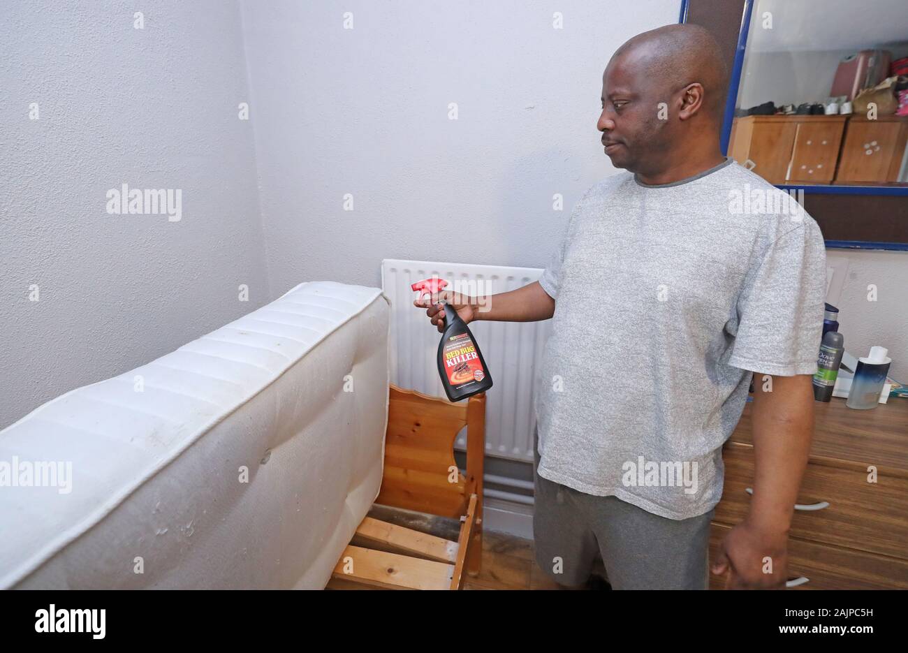 Lesley Mkoko, 51, who fled Swaziland three years ago, sprays a matress ...