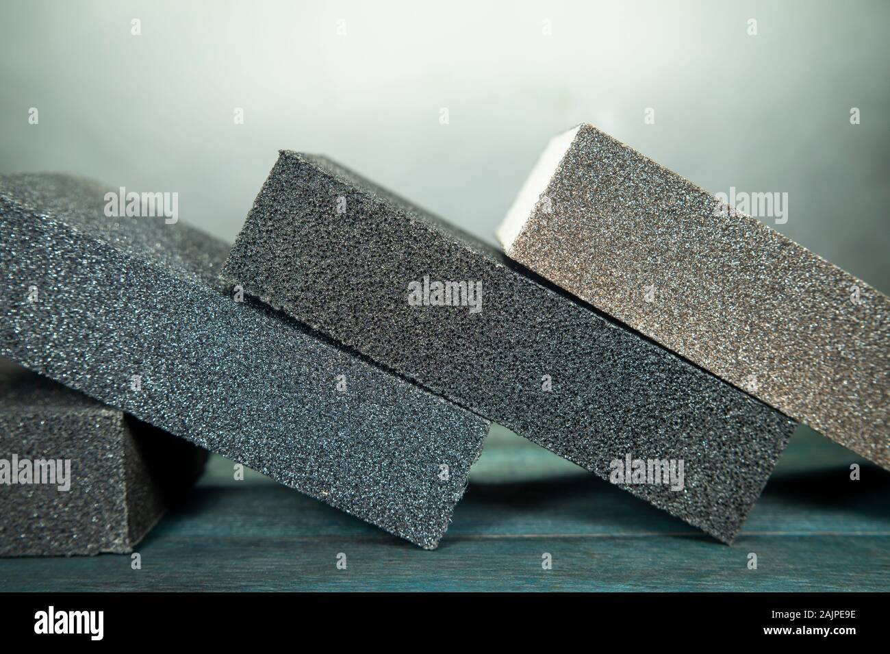 Rectangular sanding sponges stacked at a slant in a rustic still life ...