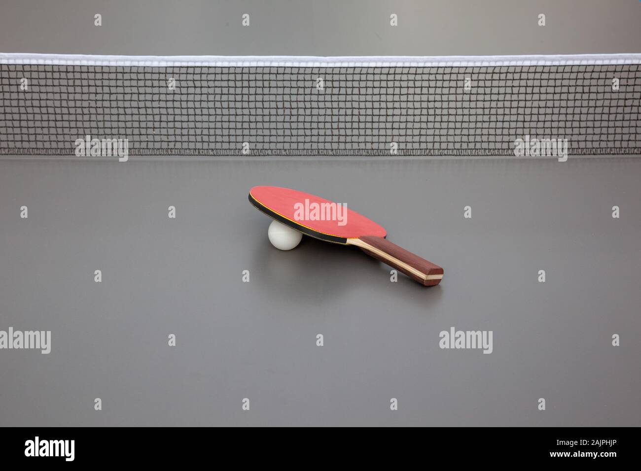 Red ping pong paddle on grey table Stock Photo - Alamy
