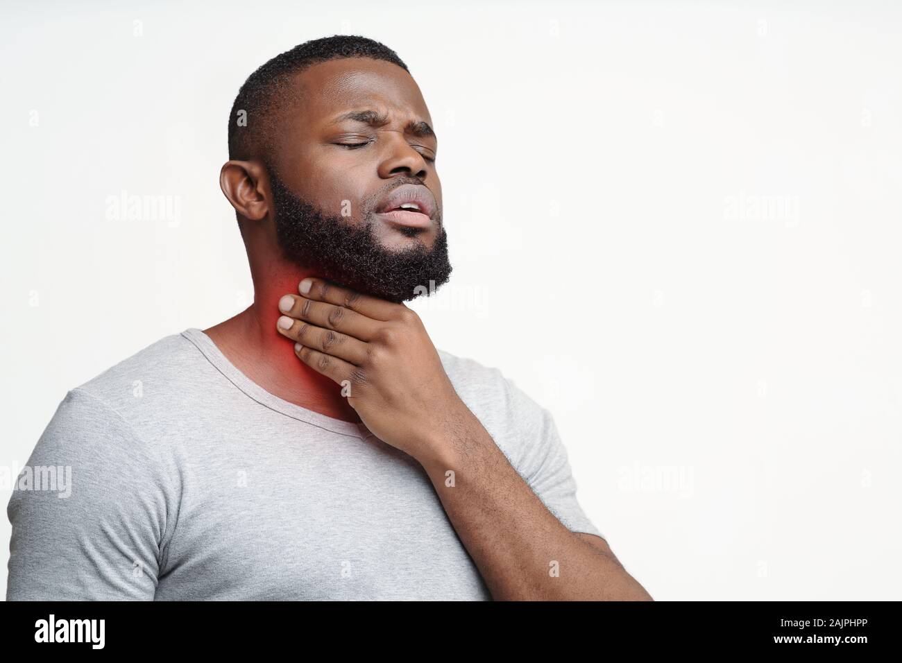 Sad black guy suffering from sore throat, touching highlighted neck ...