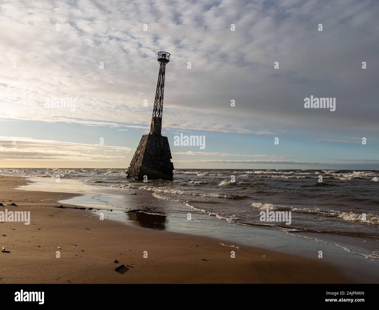 landscape with old and crooked lighthouse by the sea, windy day by the ...