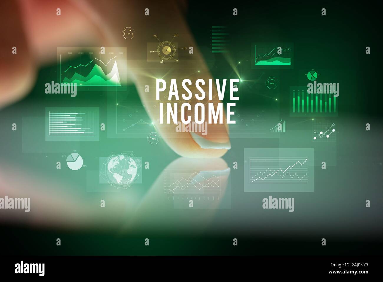 Finger touching tablet with charts and PASSIVE INCOME inscription ...