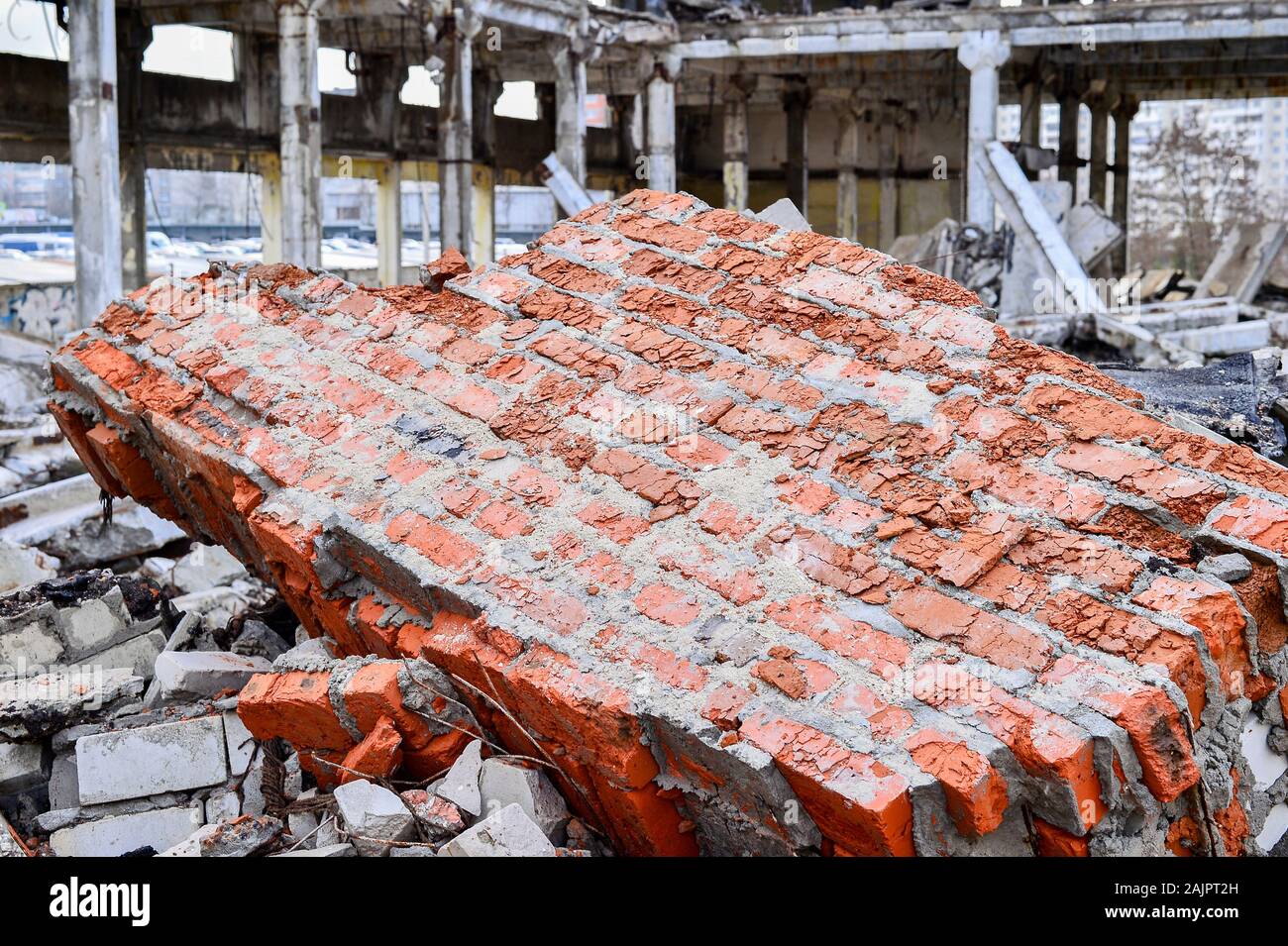 The remains of a concrete building. Part of the wall of red brick ...