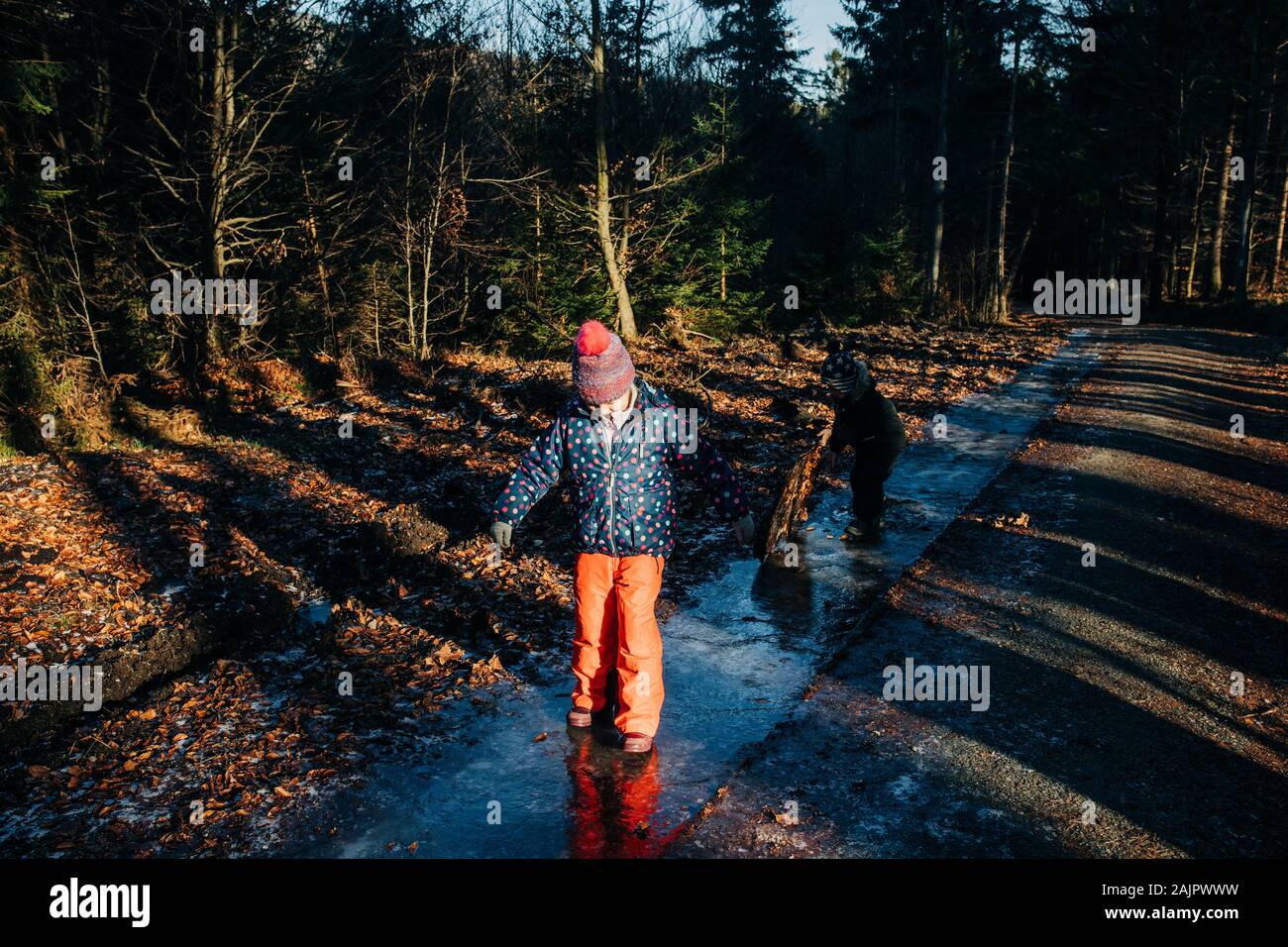 children are sliding in the woods on ice Stock Photo - Alamy