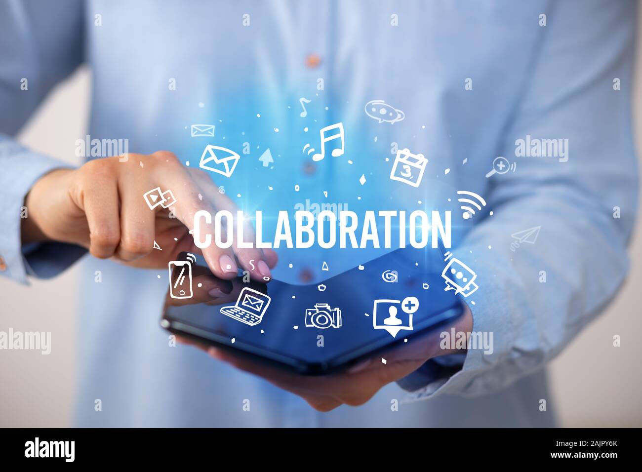 Businessman holding a foldable smartphone with COLLABORATION ...