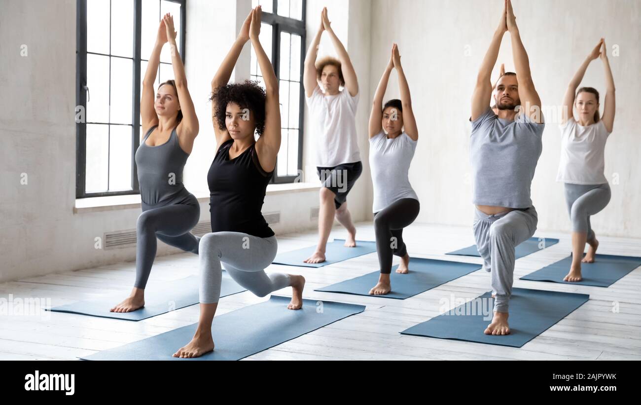 Diverse people doing Warrior one exercise at group yoga lesson Stock ...