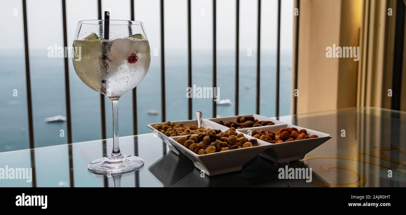 Large cocktail drink and snack of nuts in summer time Stock Photo - Alamy