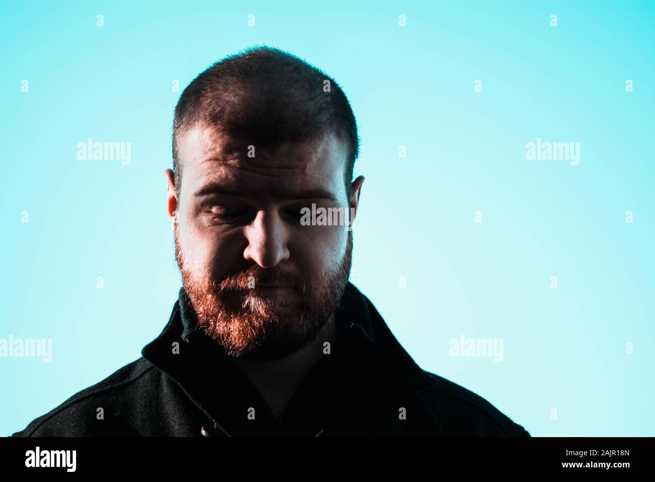 Sad depressed face of a short haired balding bearded man looking down ...