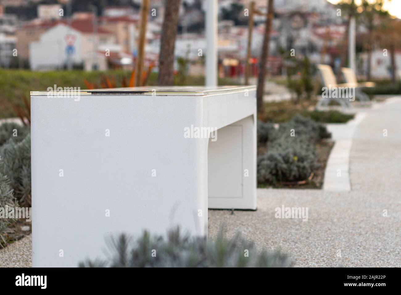 White smart bench in stobrec, croatia. Solar powered white sleek design ...
