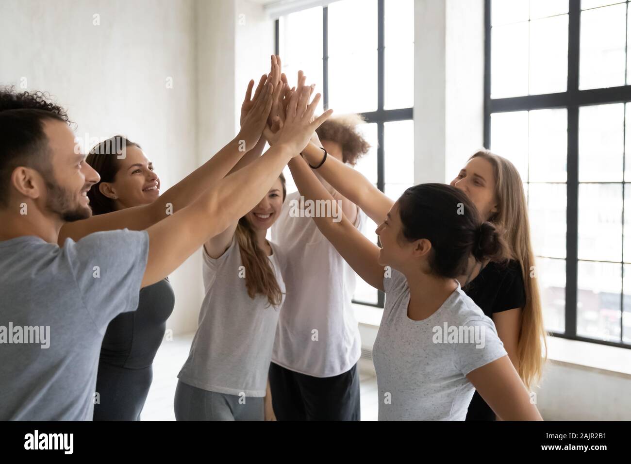 Happy diverse people giving high five in fitness center Stock Photo - Alamy