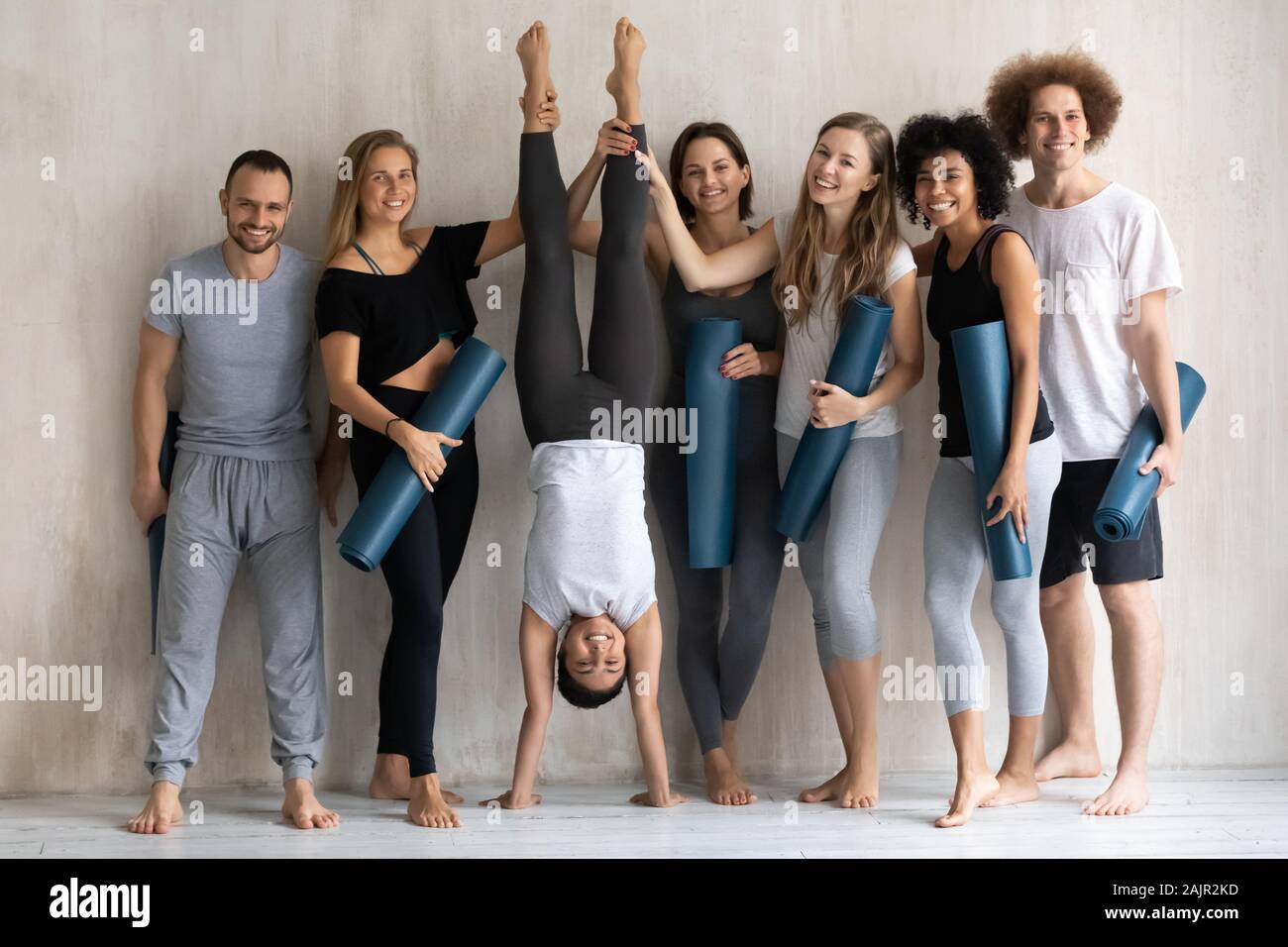 Indian woman doing Handstand, portrait smiling diverse people in studio ...
