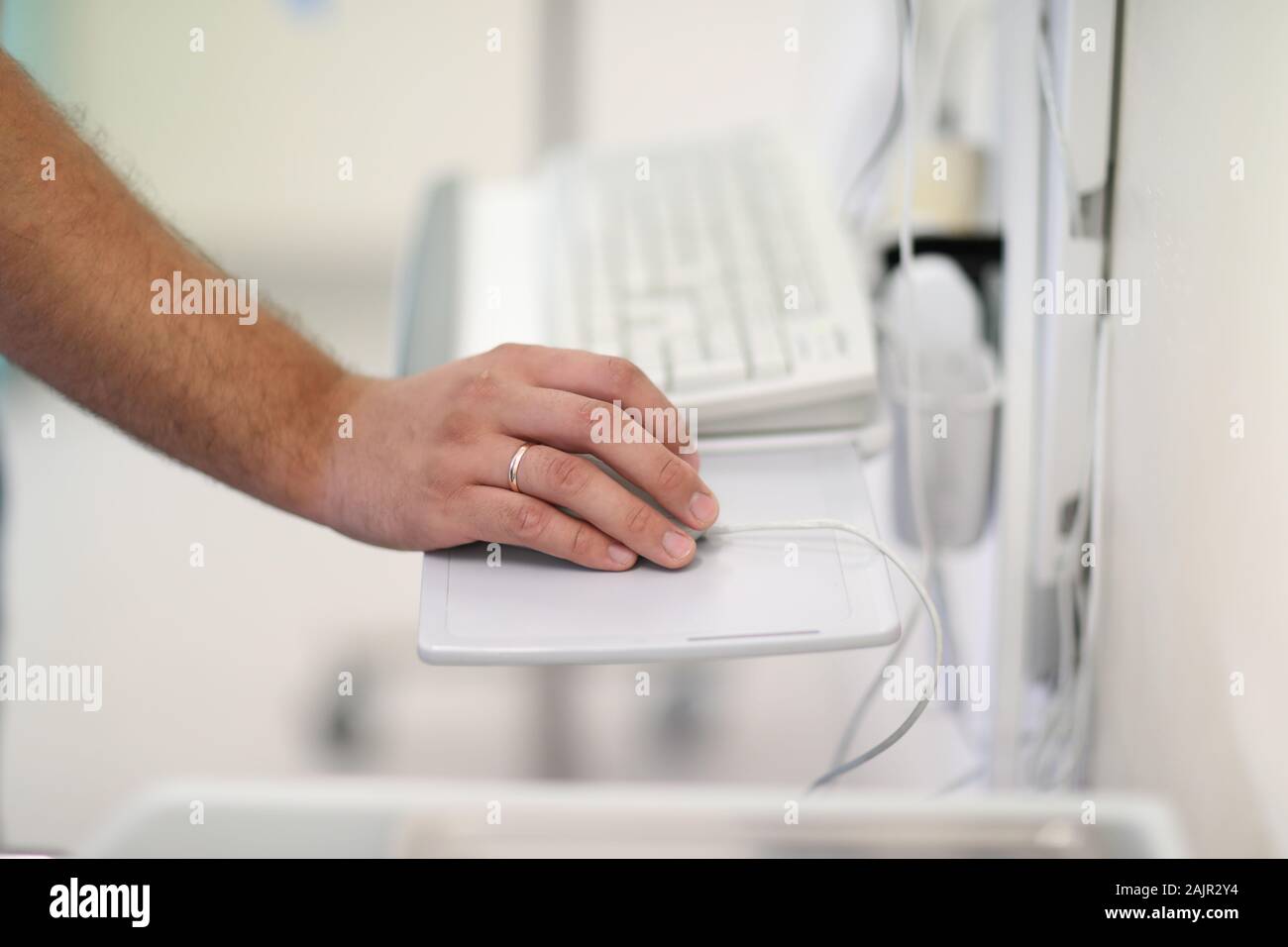 The doctor's hand on a computer mouse near the computer keyboard in the ...