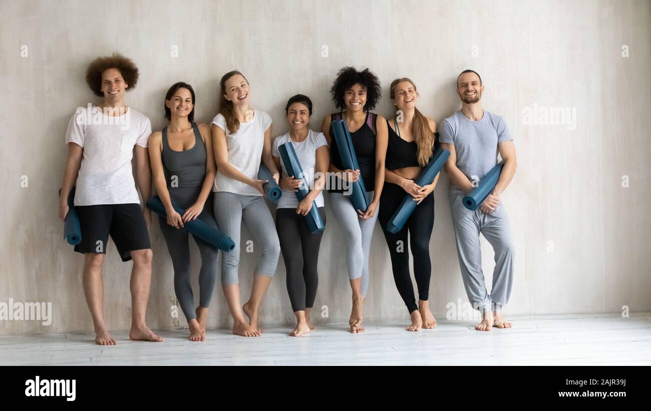 Smiling diverse people with yoga mats standing in yoga studio Stock ...