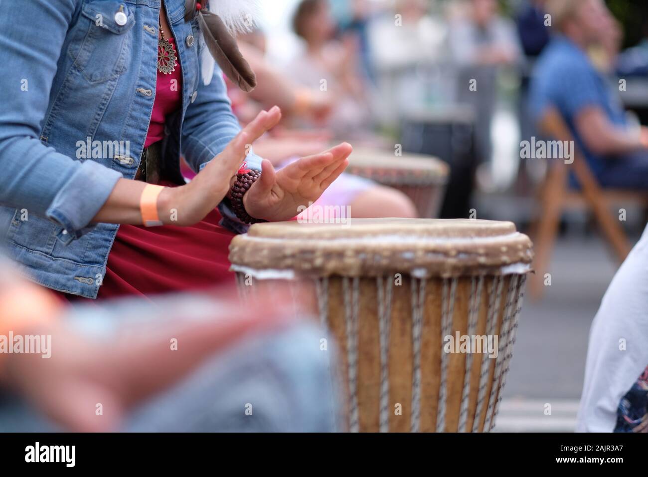 The hands of a woman playing on an African djembe drum, at a percussion ...