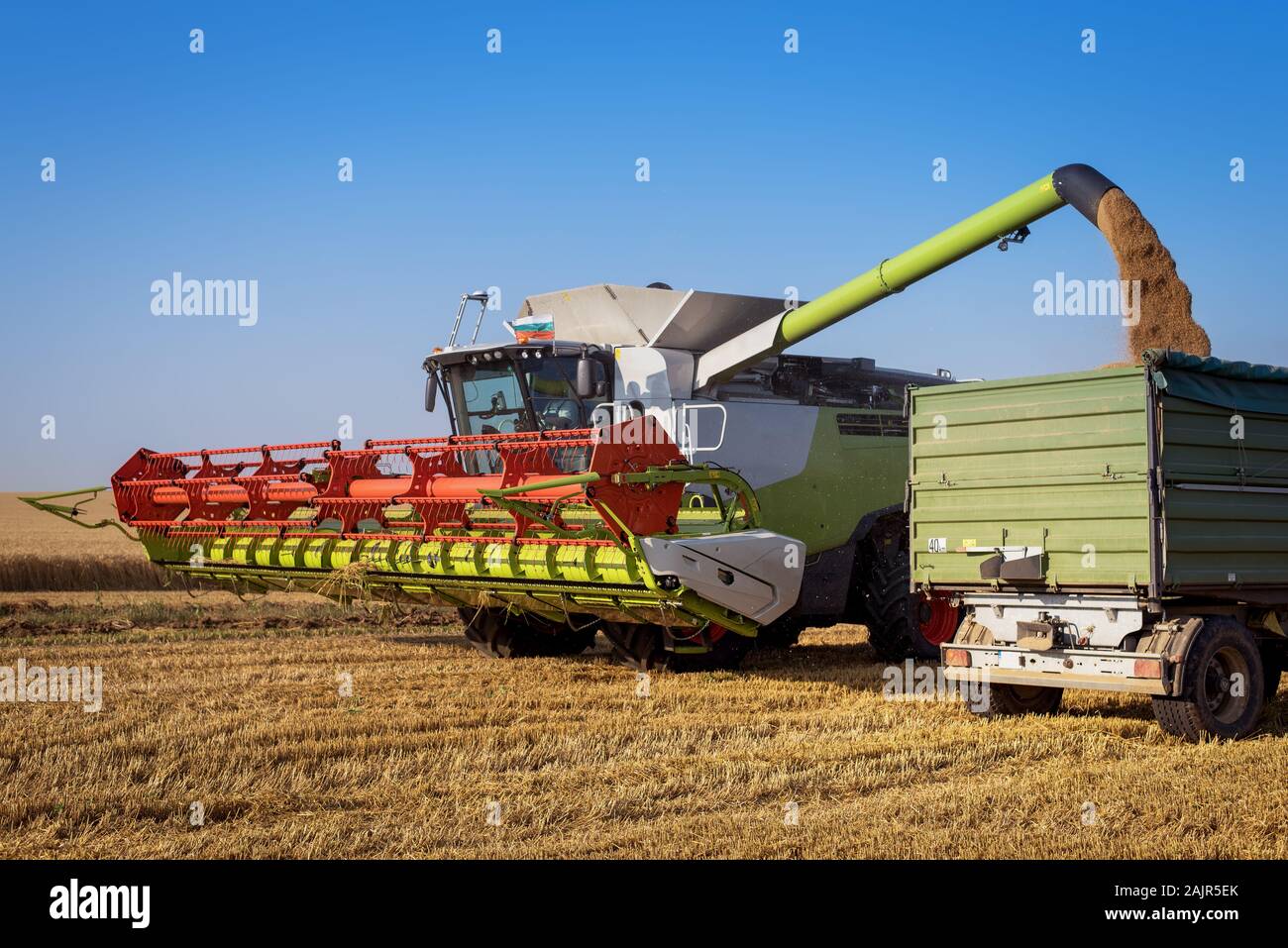 Harvest machine loading seeds in to trailer Stock Photo - Alamy