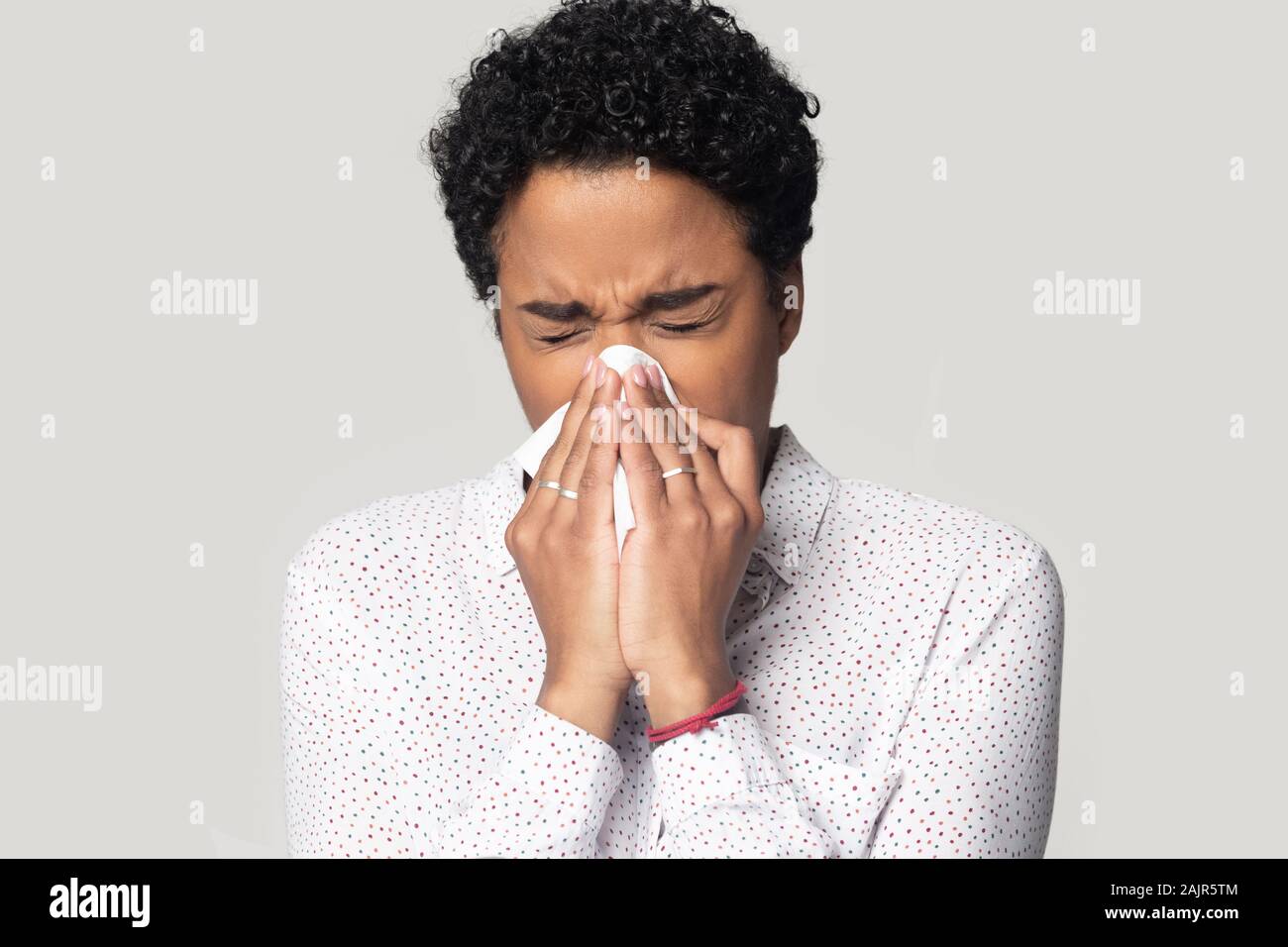 African woman holding tissue blowing running nose studio shot Stock ...