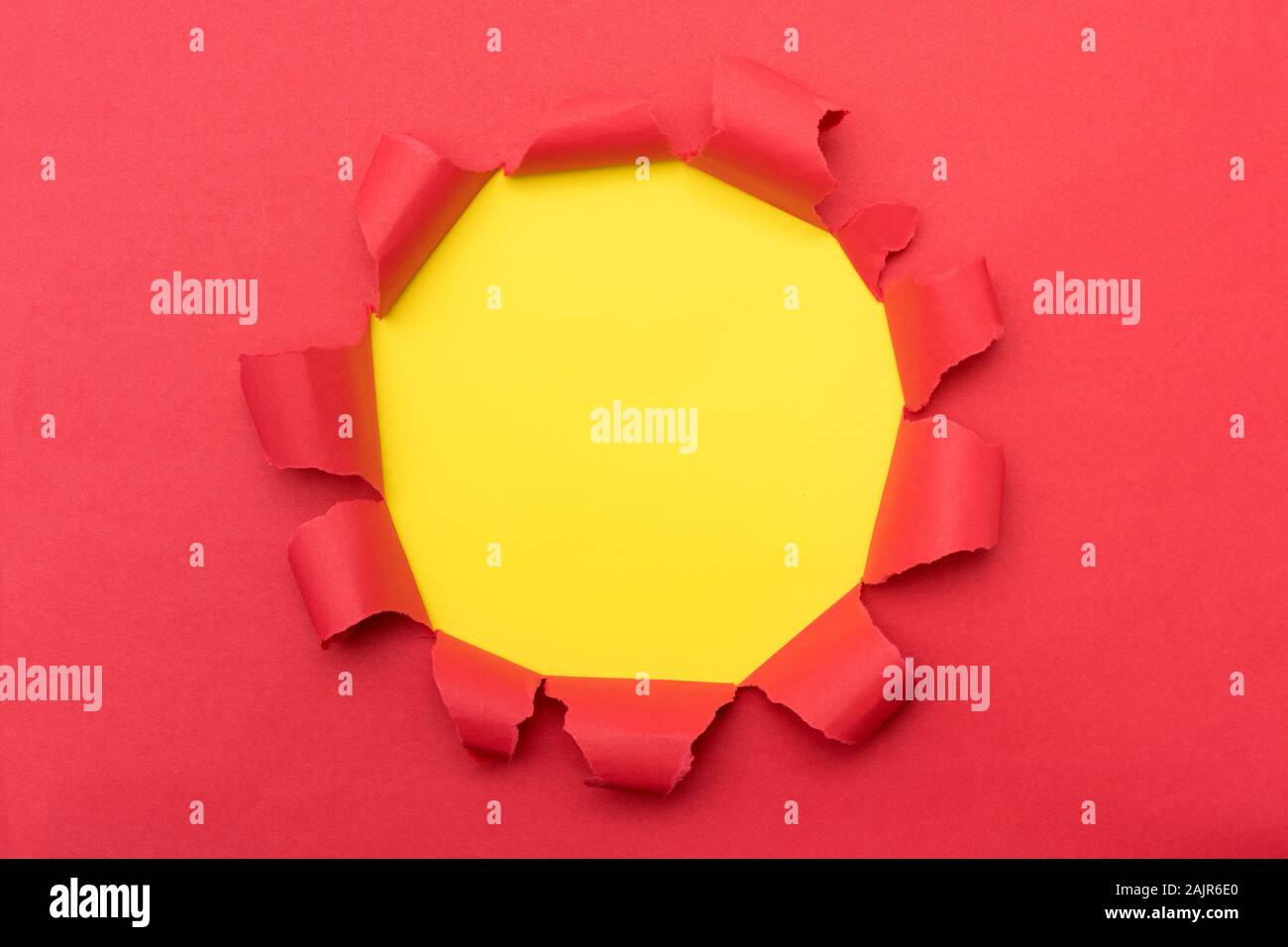 Red paper with ripped hole in the middle background Stock Photo - Alamy