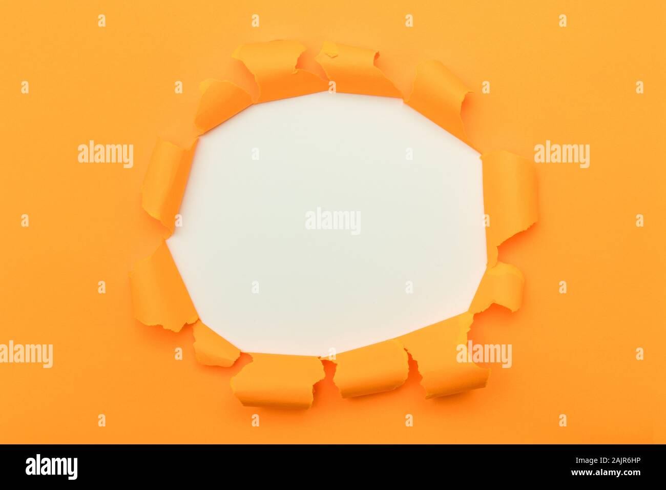 Orange paper with ripped hole in the middle background Stock Photo - Alamy