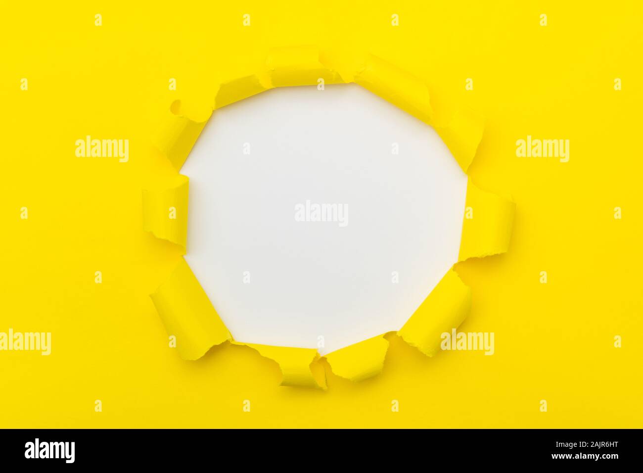 Yellow paper with ripped hole in the middle background Stock Photo - Alamy