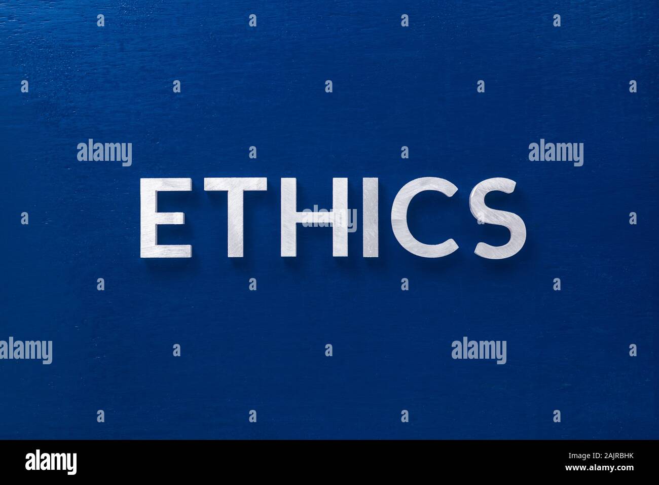 the word ethics laid with silver metal letters on classic blue board in ...