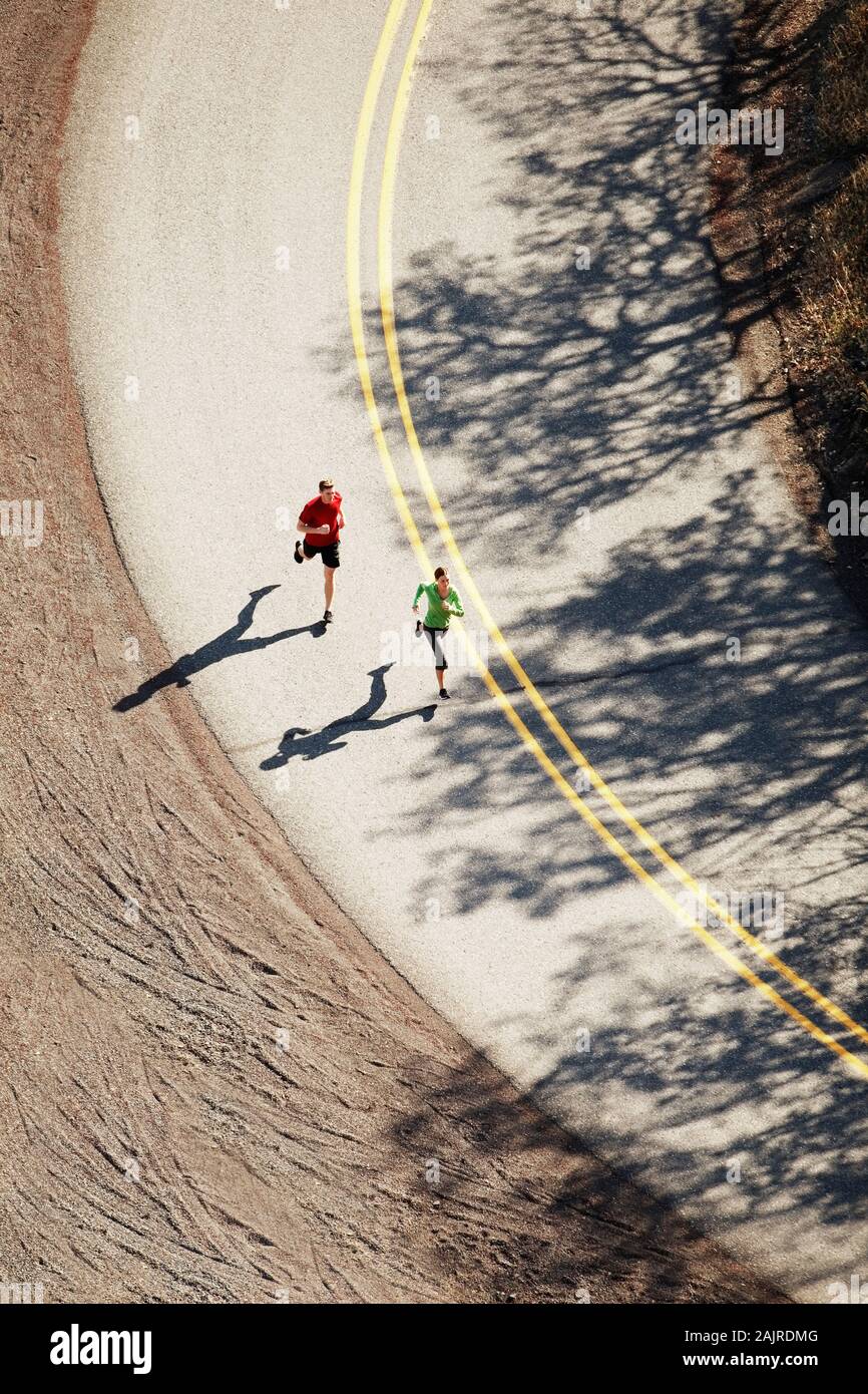 Aerial of two runners running on sunny country road Stock Photo - Alamy